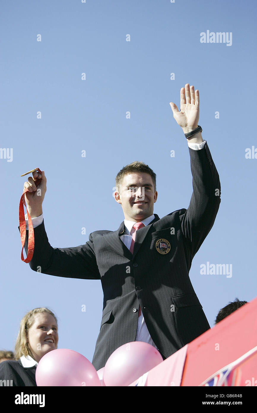 Great Britain's Olympic Rower Peter Reed waves as they ride on an open ...