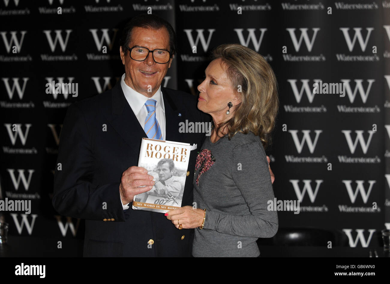 Roger Moore poses with his wife, Kristina, as he signs copies of his ...