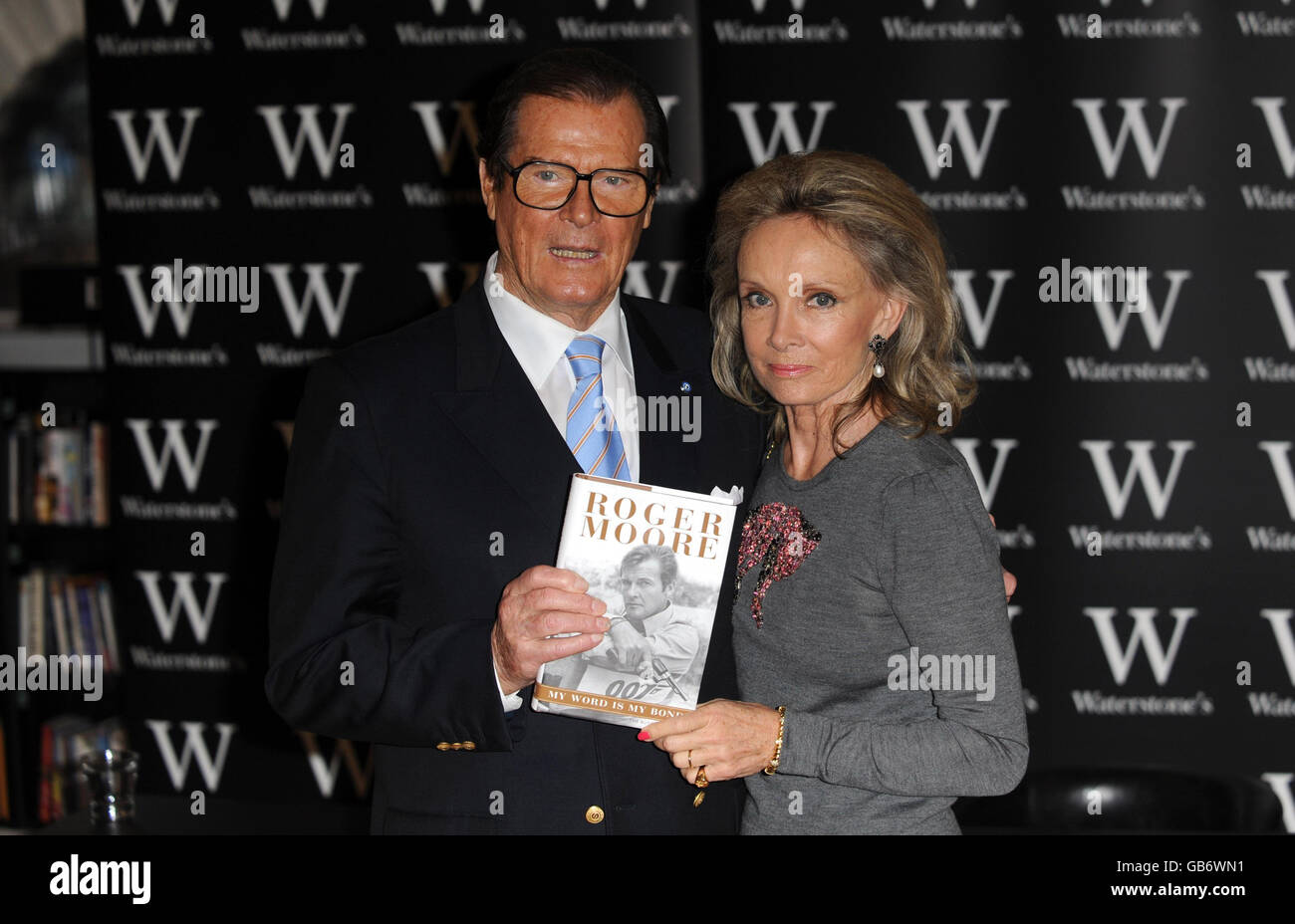 Roger Moore poses with his wife, Kristina, as he signs copies of his ...