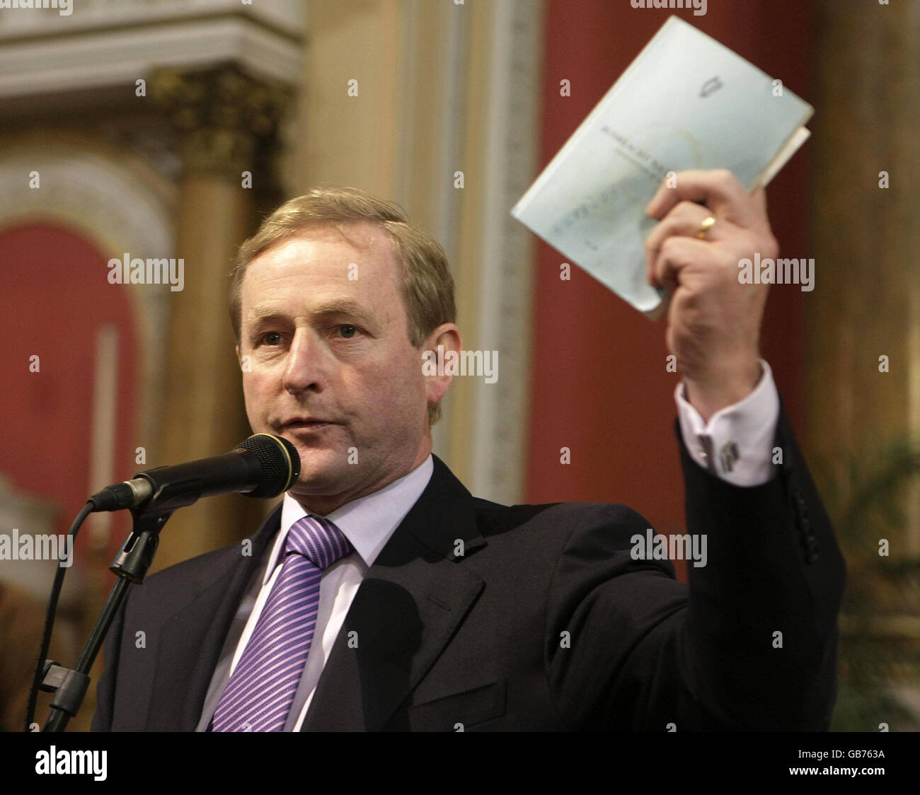 Fine Gael Leader Enda Kenny holds up a copy of the Irish Constitution ...