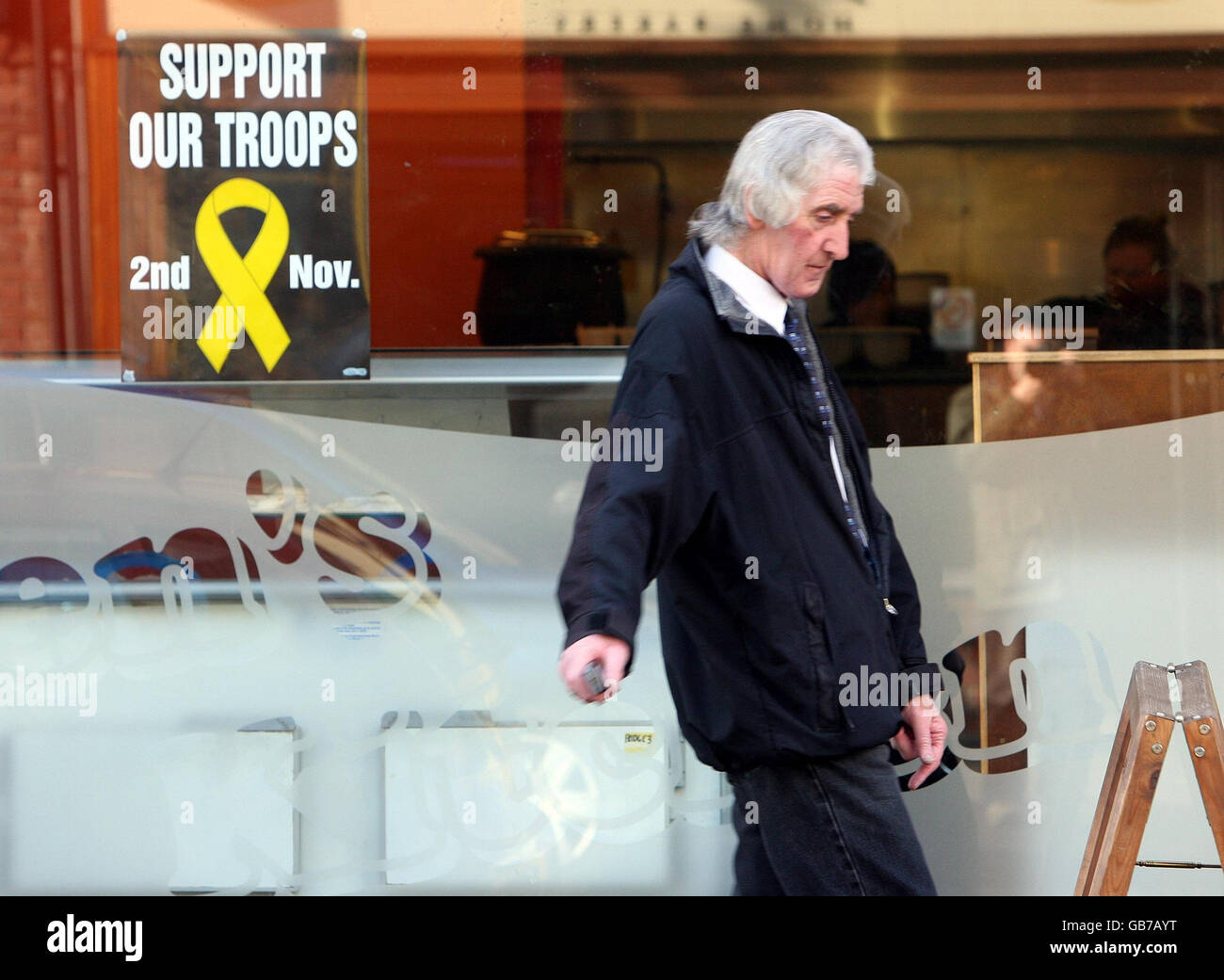 People walk past yellow ribbons on Sandy Row in Belfast. The body that ...