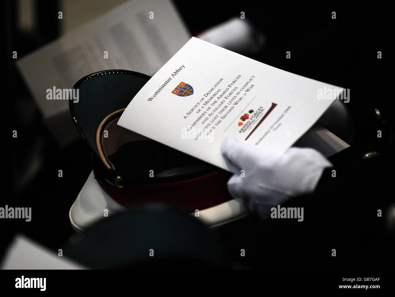 A member of the services holds an order of service during a remembrance ...