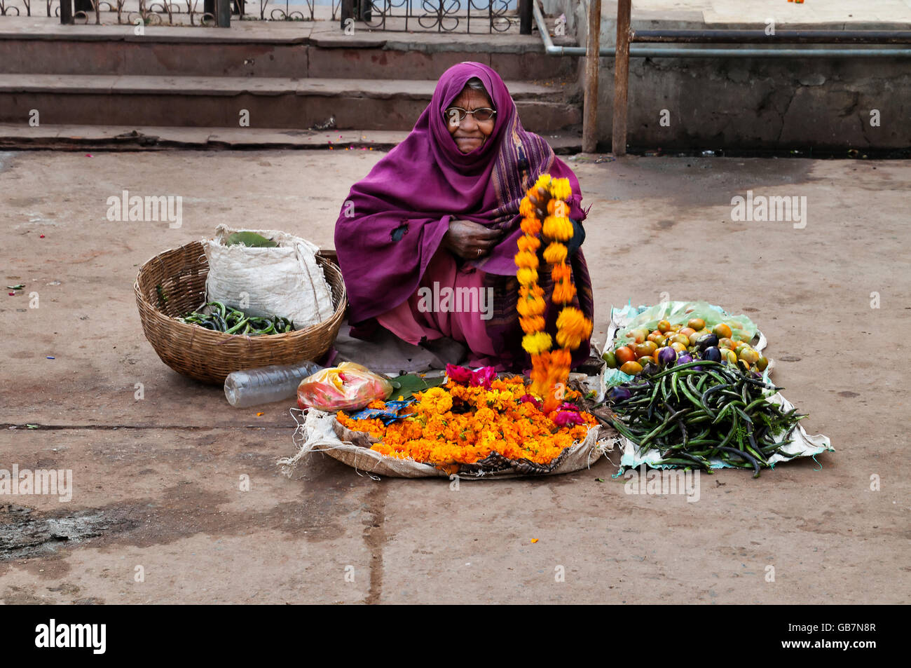 Unidentified old poor woman sells garlands of flowers at the temple ...