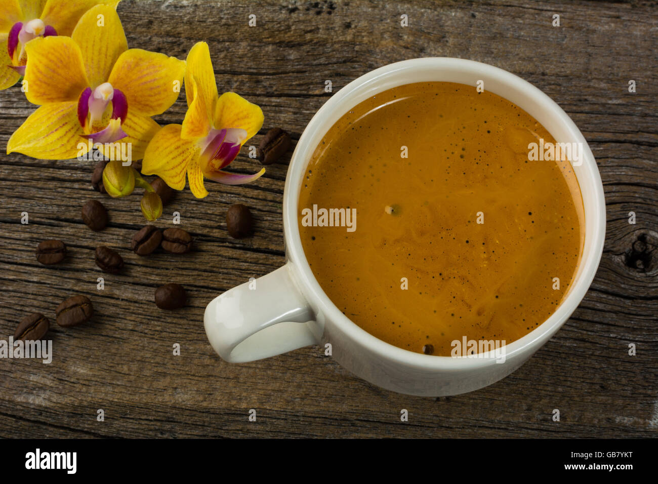 Coffee cup and yellow orchid on the wooden background. Morning coffee ...