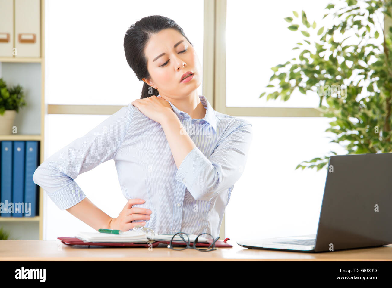 Young asian business woman with pain in shoulders in office Stock Photo ...