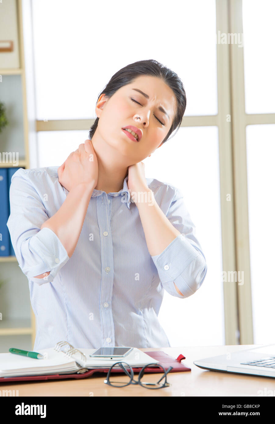 Young asian business woman with pain in neck in office Stock Photo - Alamy