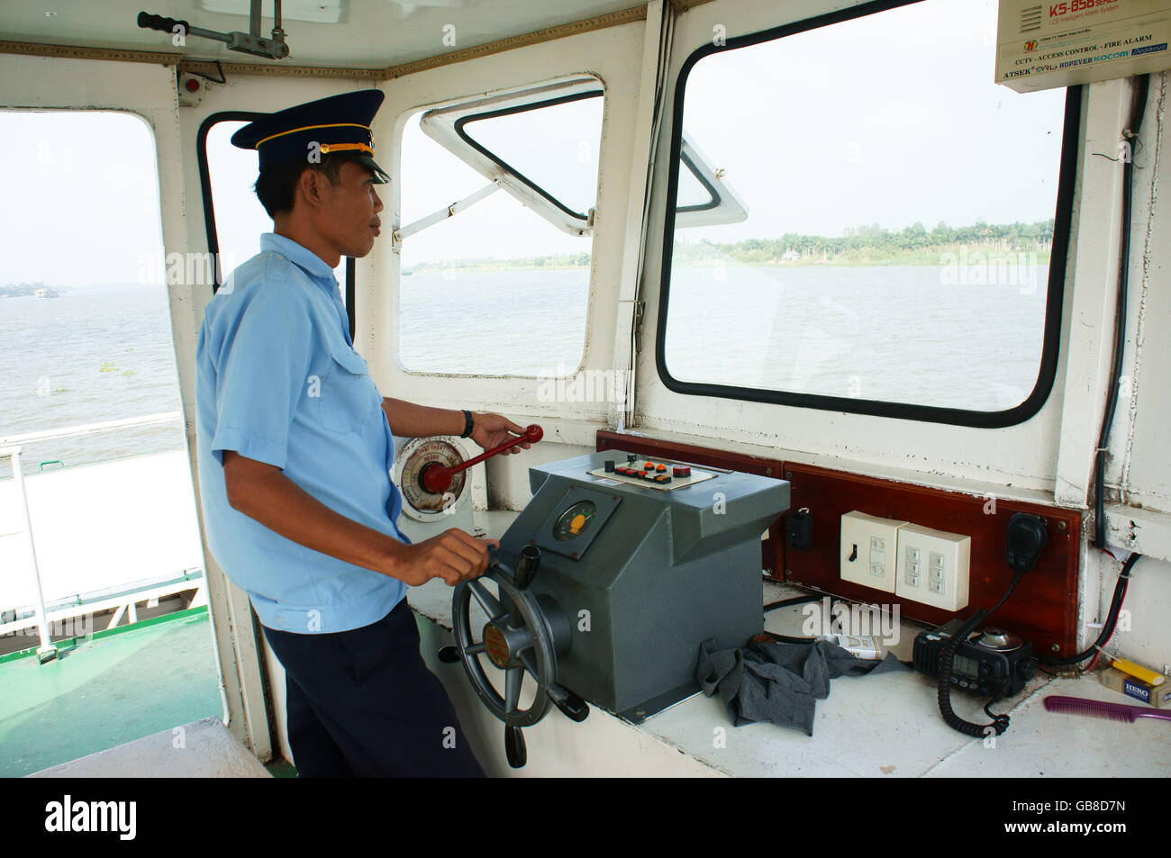 On cabin of ferry boat, ferryman wear uniform control the wheel to ...