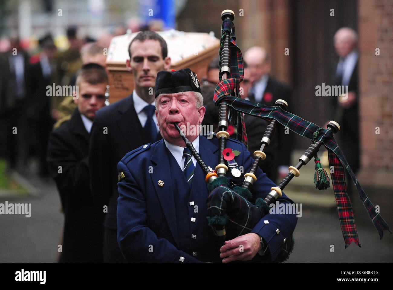 The coffin of Joseph Lappin is led away by a piper after his funeral ...