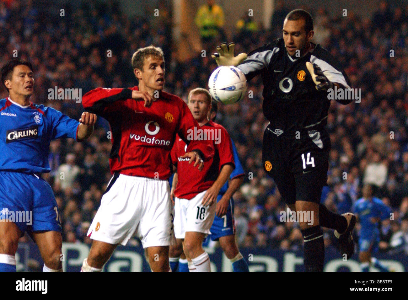 Manchester United's Tim Howard (r) gathers the ball closely guarded by ...