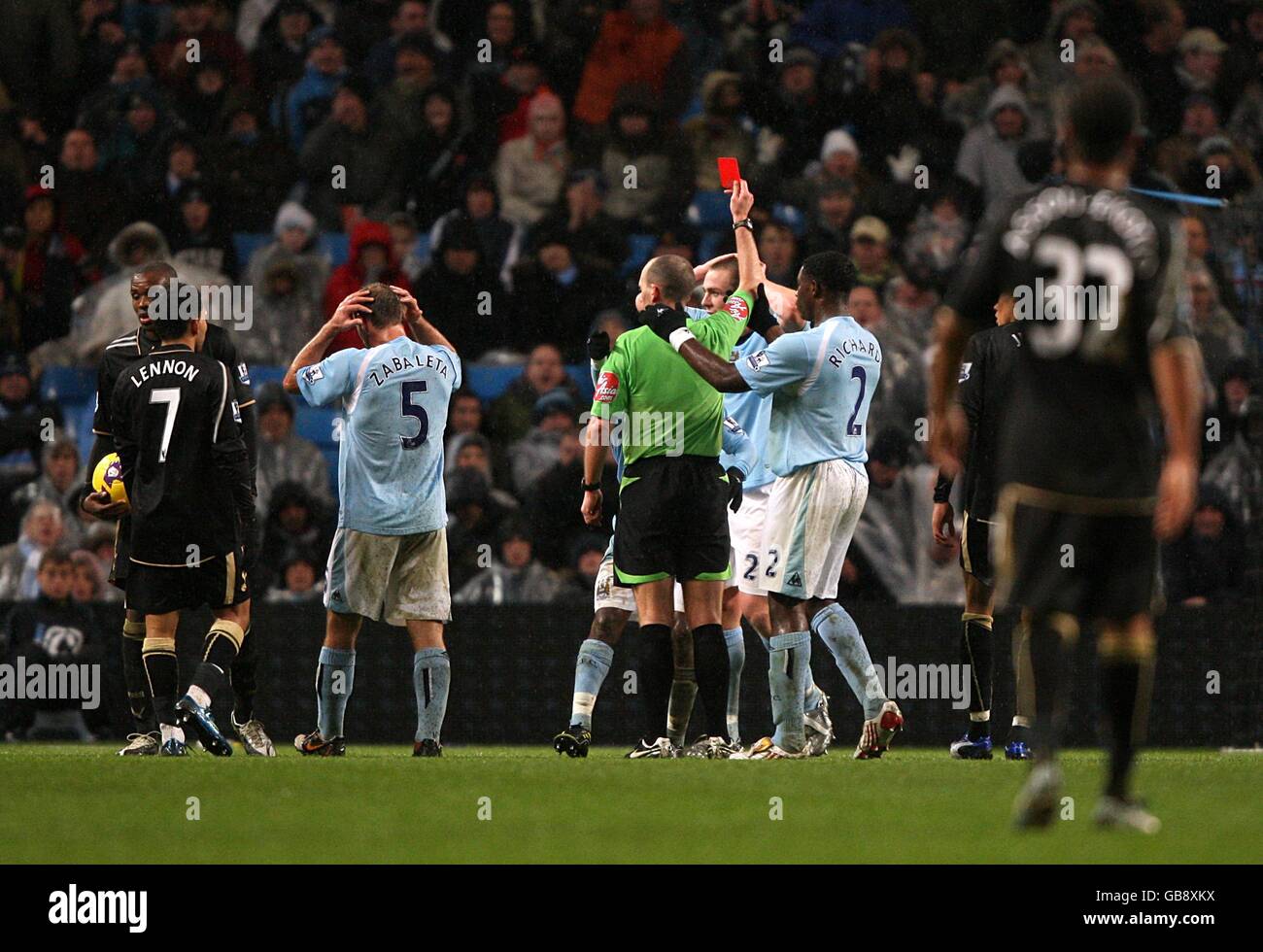 Referee Mike Dean shows the red card to Manchester City's Richard Dunne ...