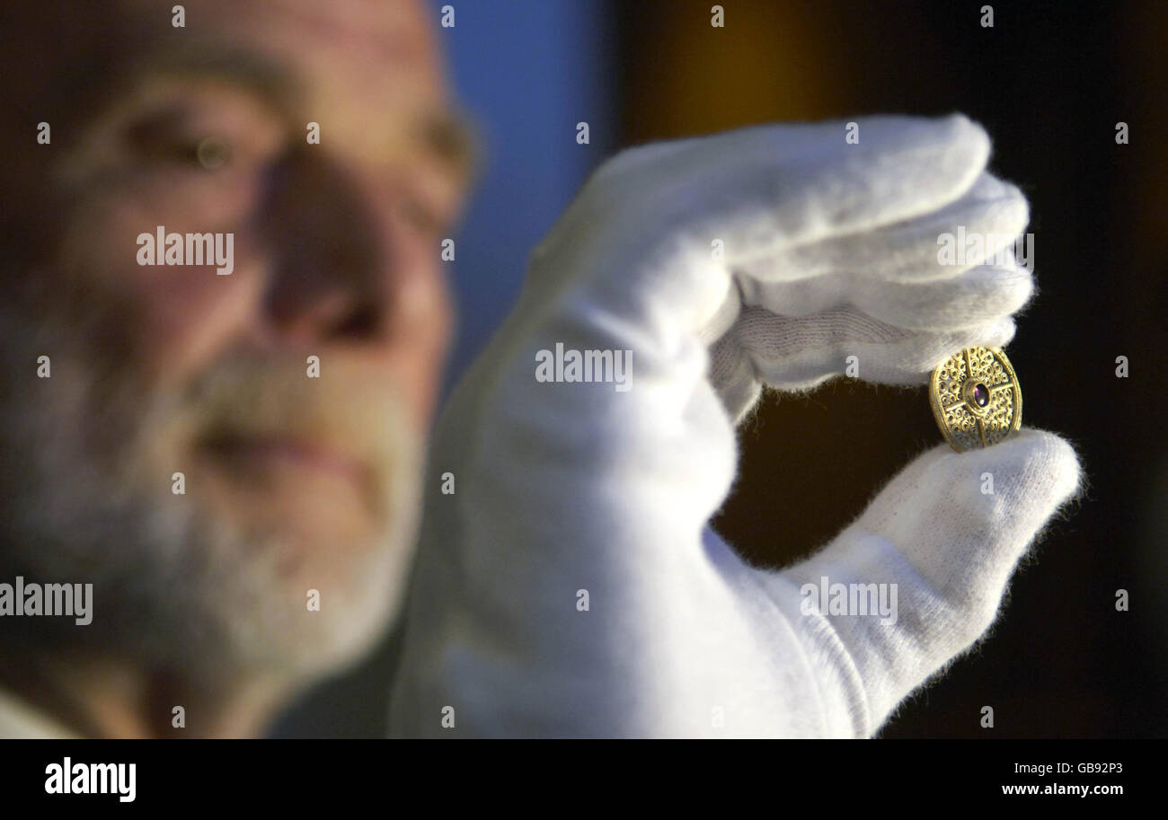 A Seventh century Anglo-Saxon mount held up for a closer look by its ...