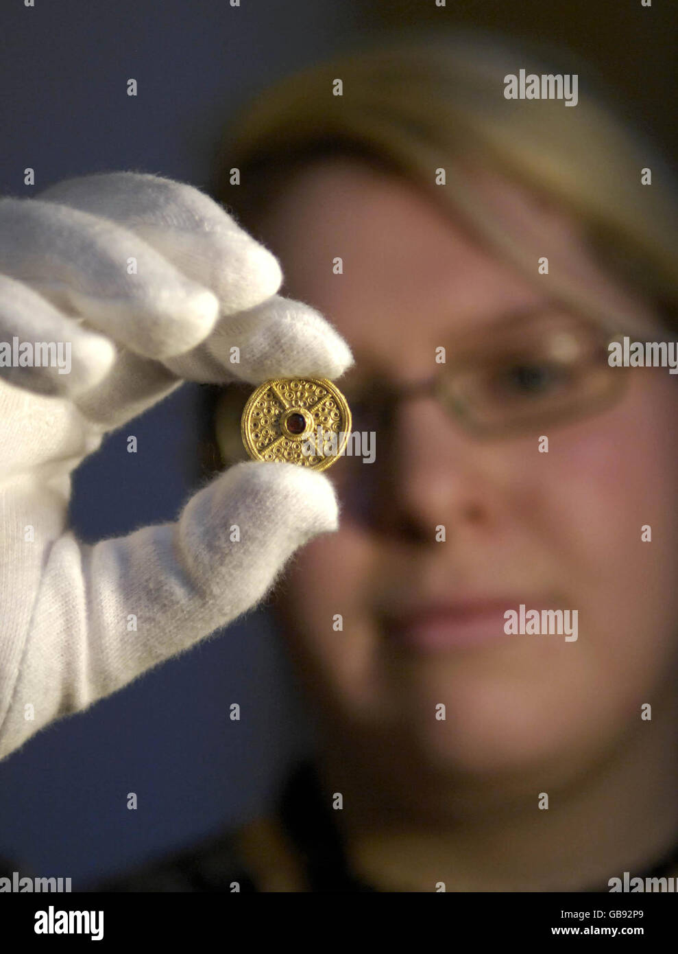 A Seventh century Anglo-Saxon mount held up for a closer look by a ...