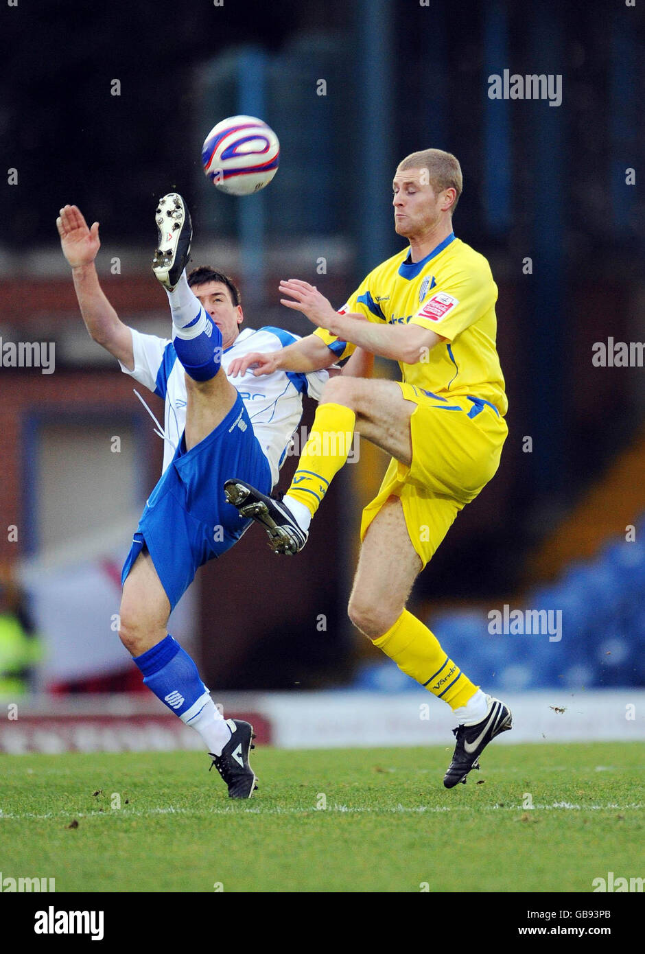 Bury's David Buchan (left) clears the ball whilst under pressure from ...