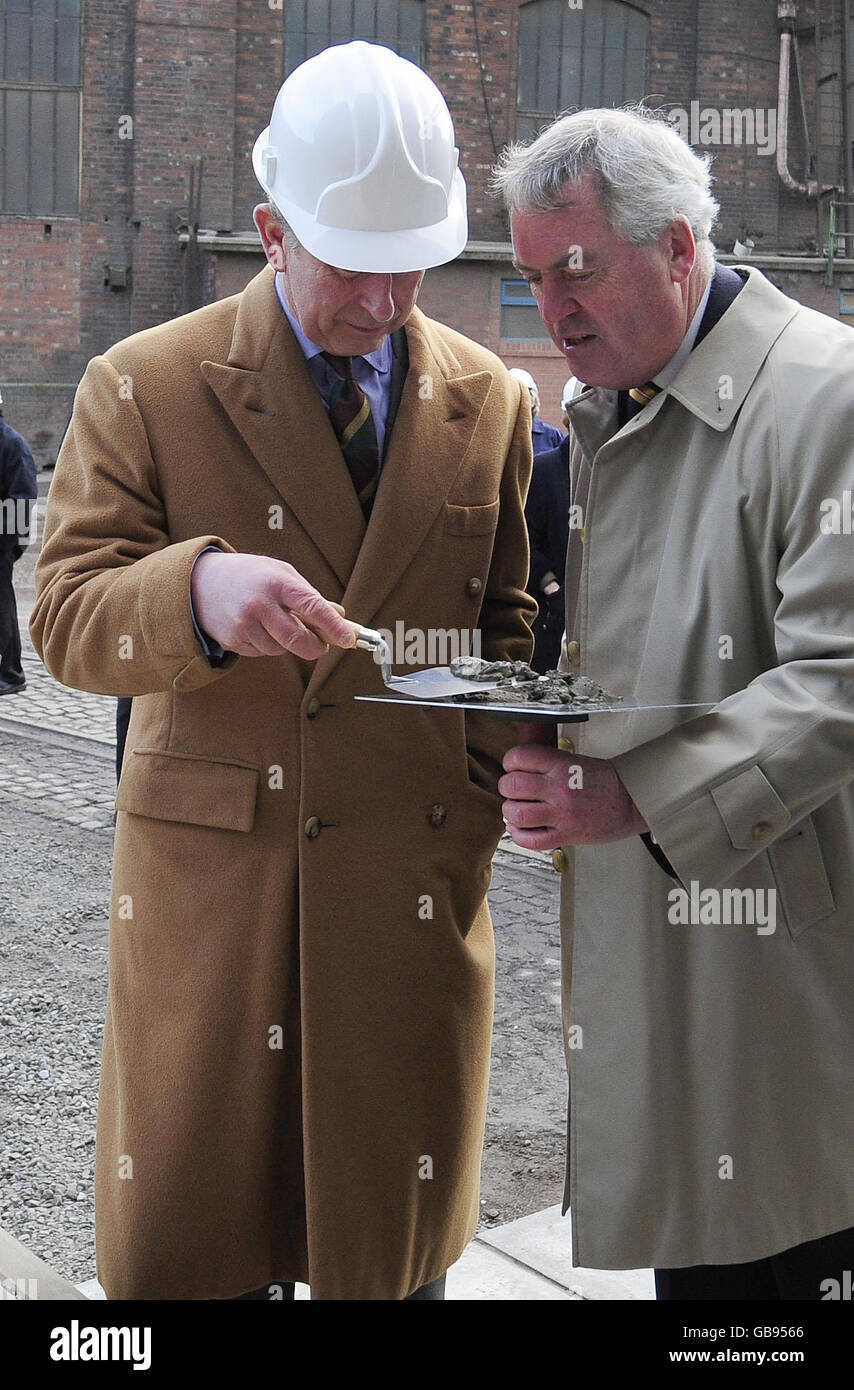The Prince of Wales uses a builders trowel as he prepares to unveil a ...