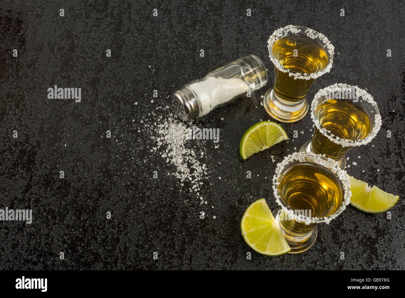 Gold tequila with lime on black background, top view. Tequila shot ...