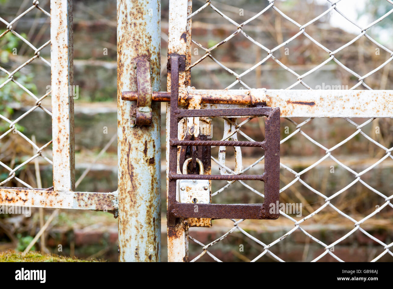 Closed old rusty gate with padlock Stock Photo - Alamy