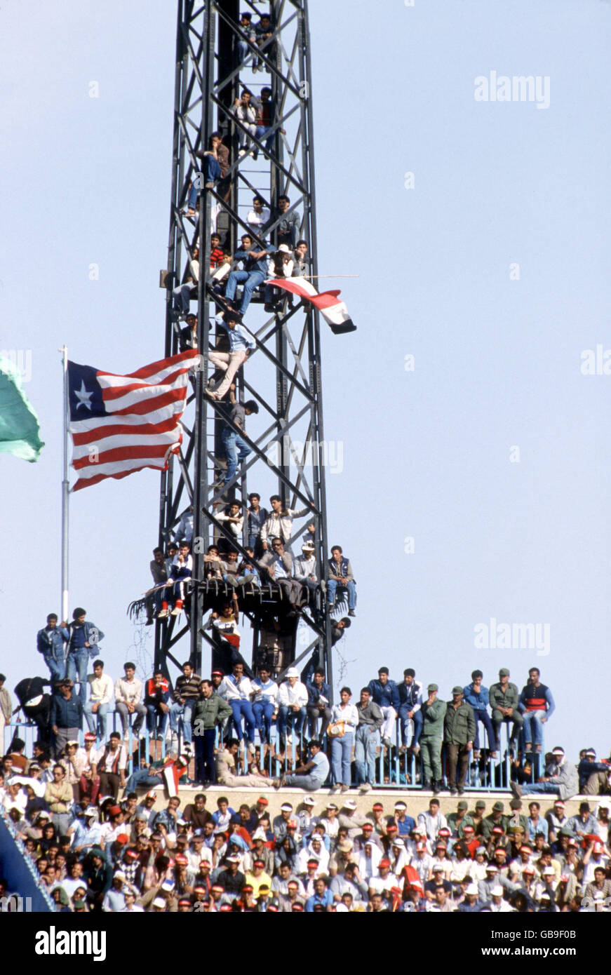 Fans watch the final from elevated positions on a floodlight pylon ...