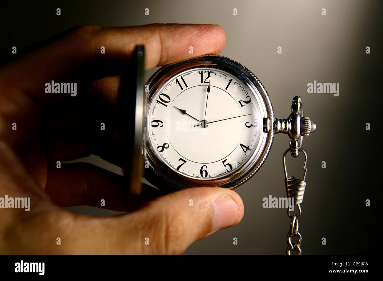Photo of a hand holding a vintage silver round pocket watch with silver ...