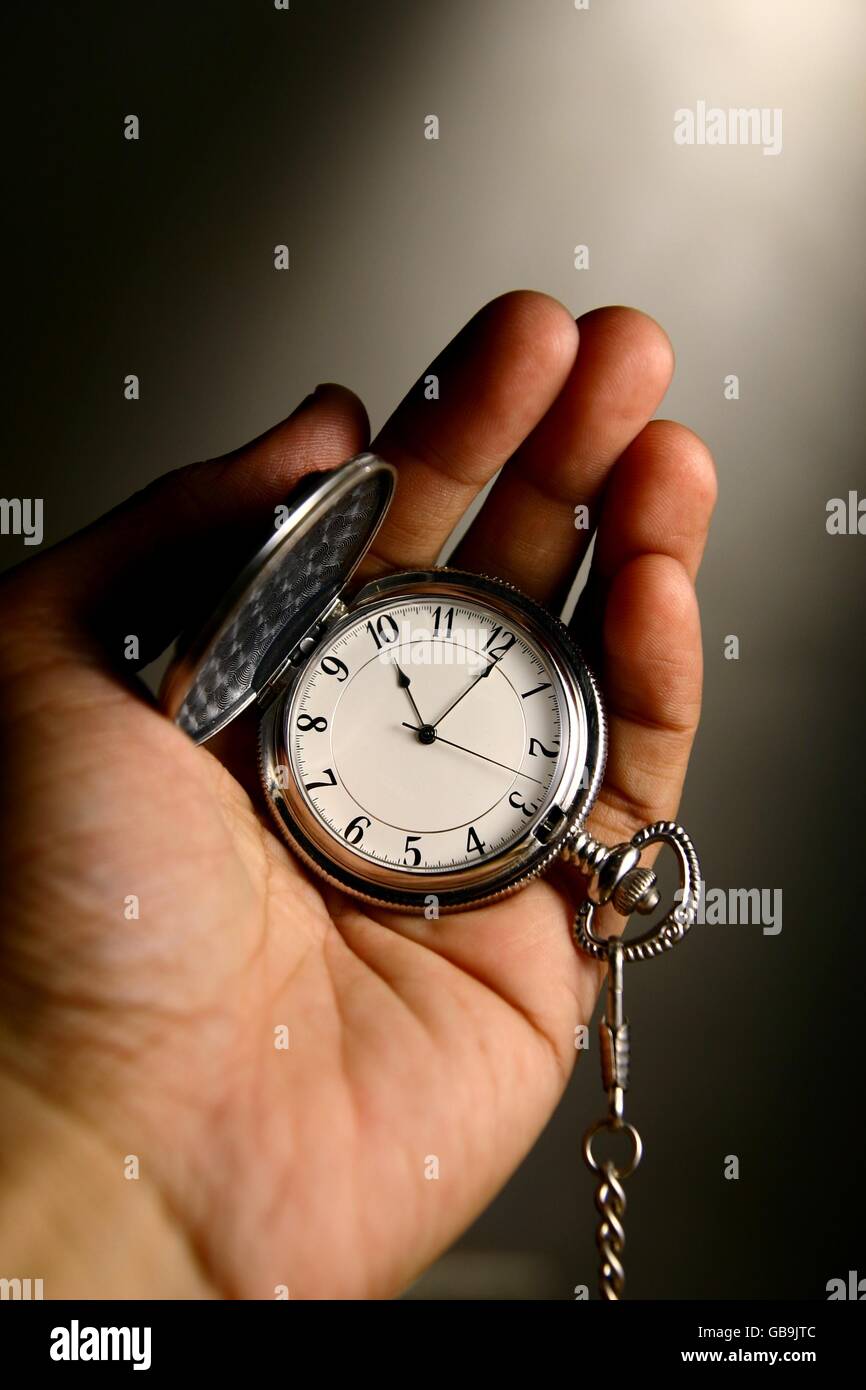Photo of a hand holding a vintage silver round pocket watch with silver ...