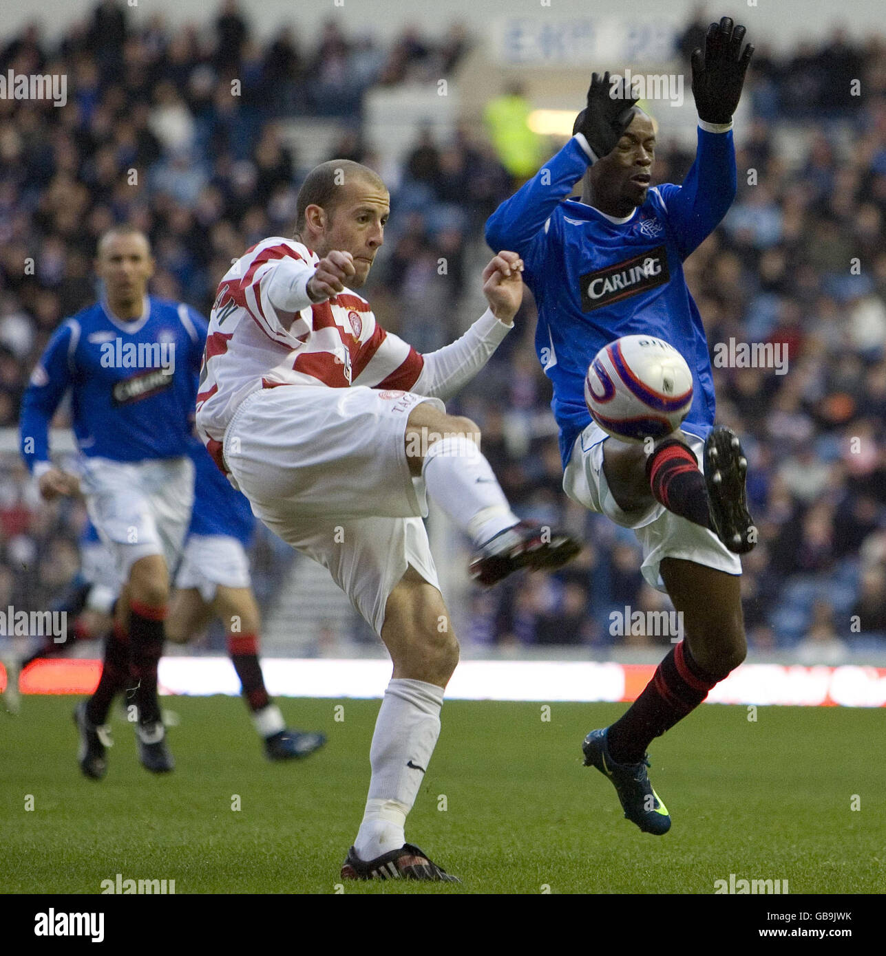 Hamilton's Trent McClenahan clears the ball under pressure from Rangers ...