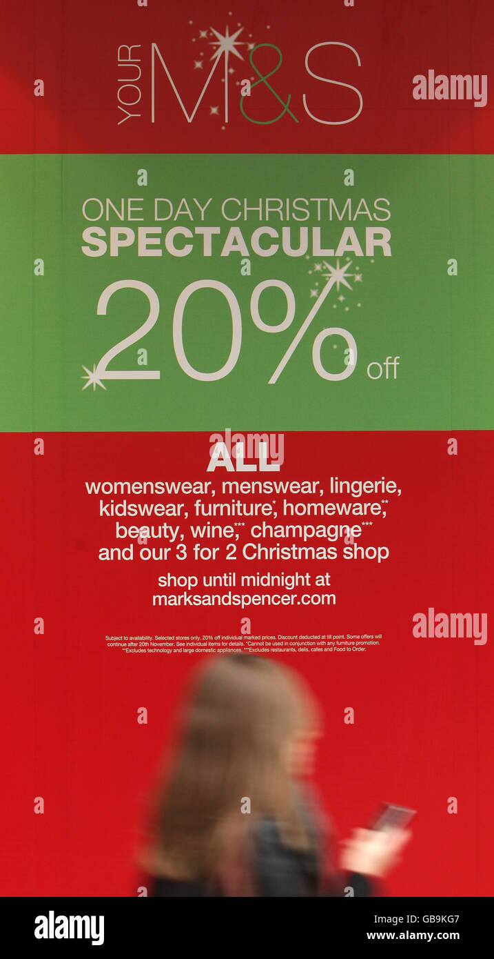 High Street sales. Shoppers walk past sale signs in the window of a ...