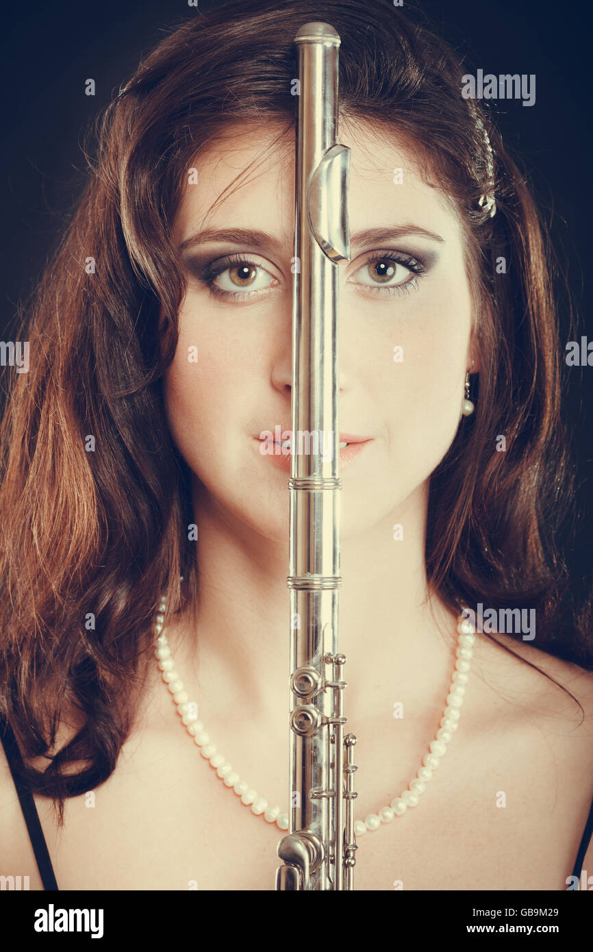 Music performance. Stunning elegant young lady with transverse flute ...