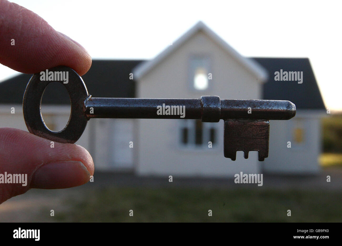 A house key held in front of a house hi-res stock photography and ...