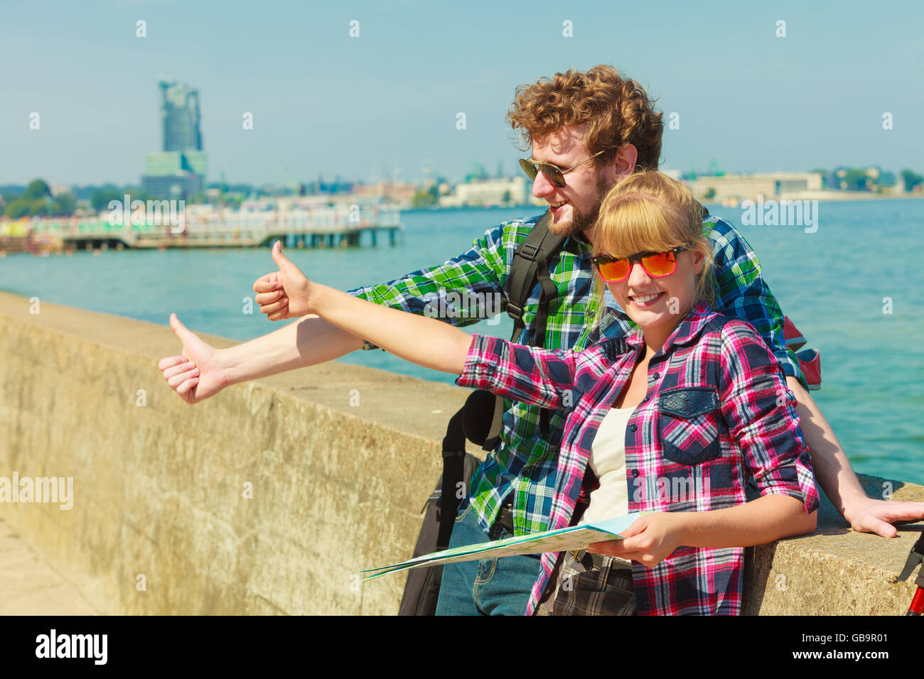 Adventure, summer, tourism. Young couple backpacker hitchhiker with map ...
