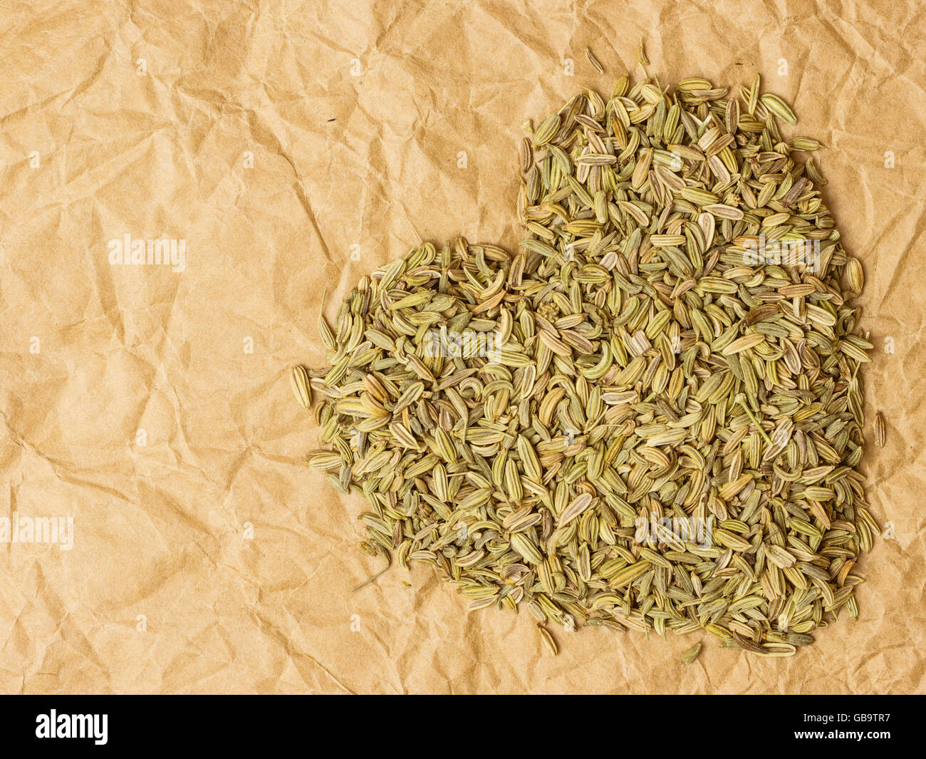 Dried fennel dill seeds heart shaped on paper surface Stock Photo - Alamy