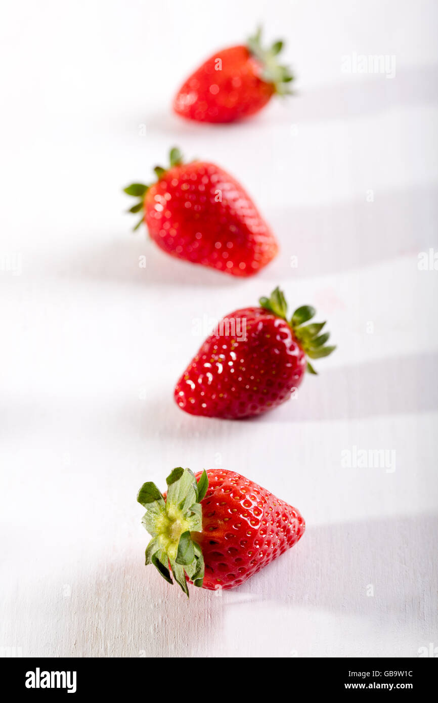 Four juicy strawberry on the table Stock Photo - Alamy
