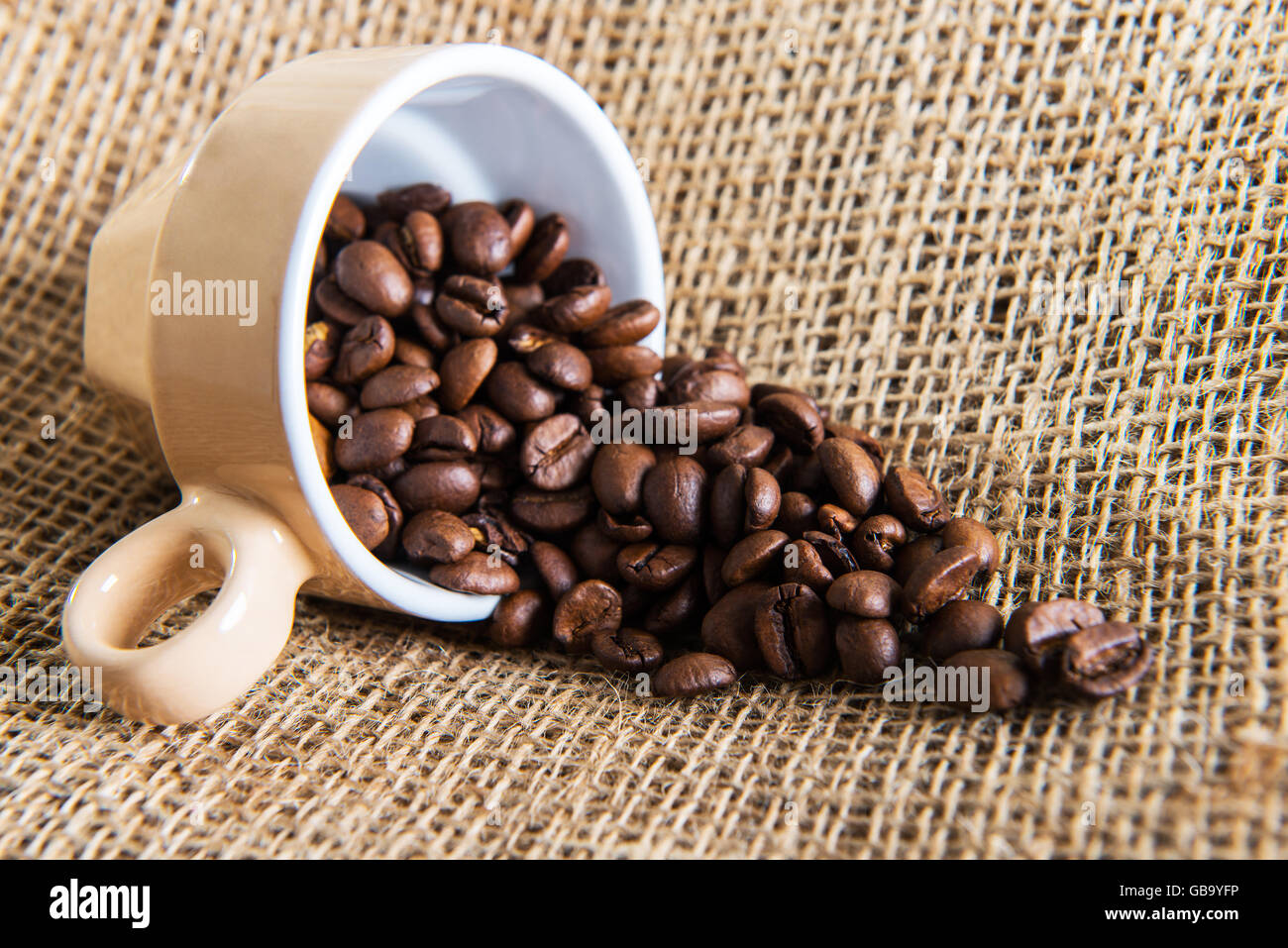Beige cup with coffee seed on jute bag Stock Photo - Alamy