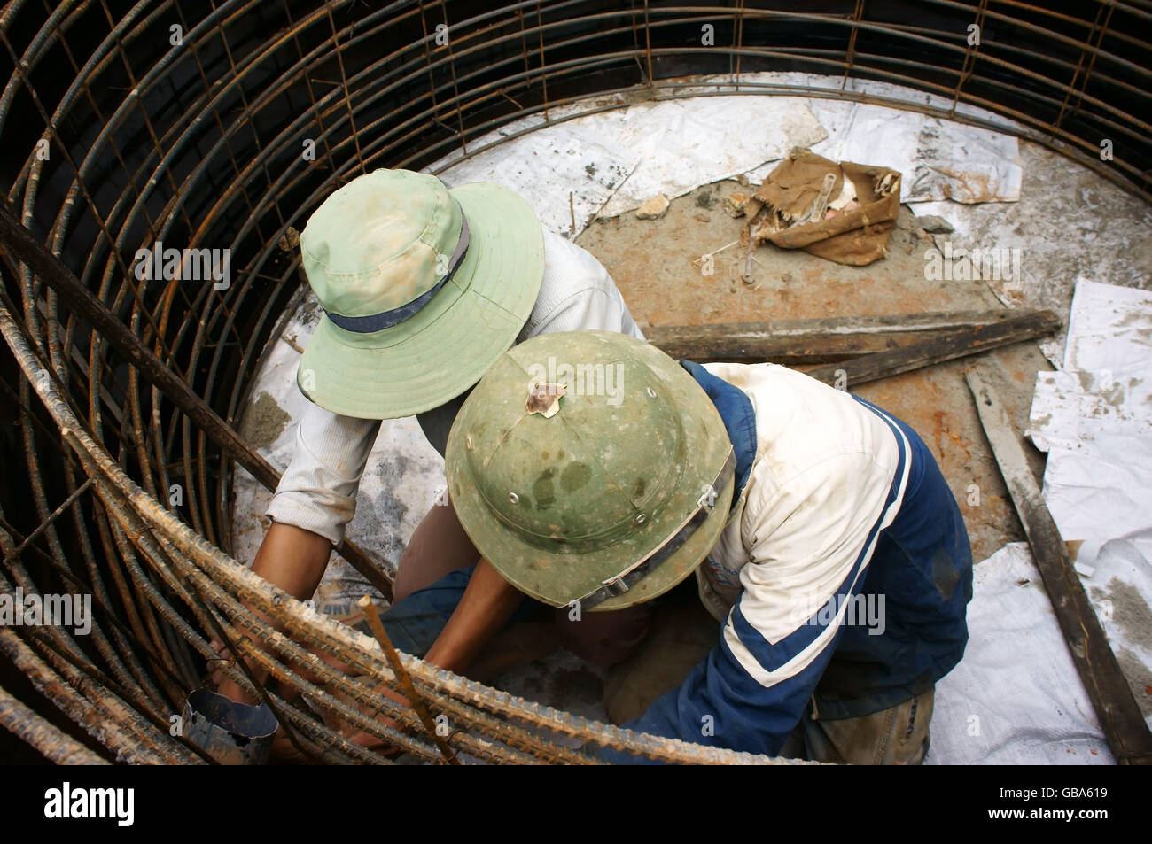 Two Workers with splitter on hand try to split large rock into small ...