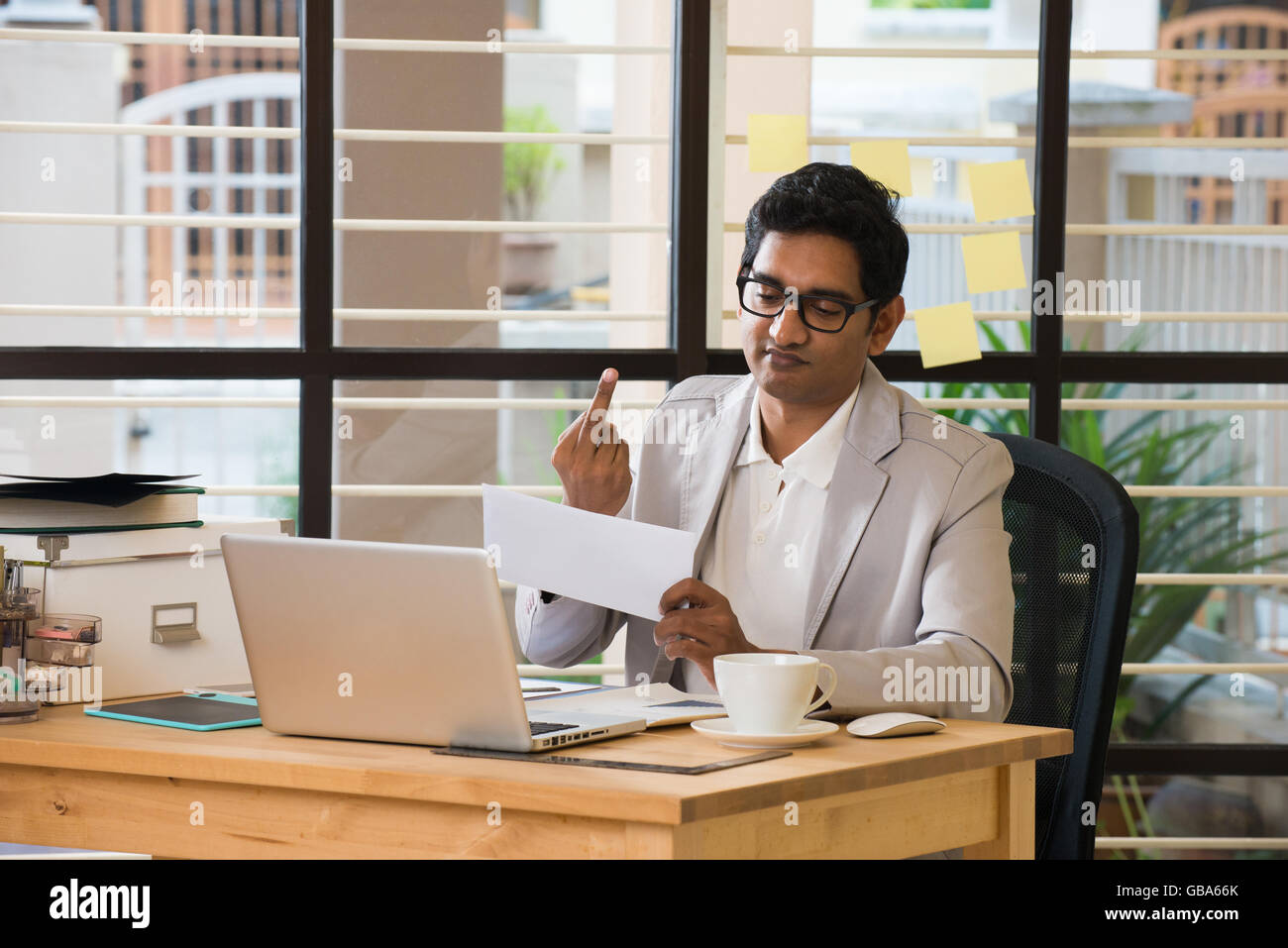 indian male with a letter looking and middle finger Stock Photo - Alamy