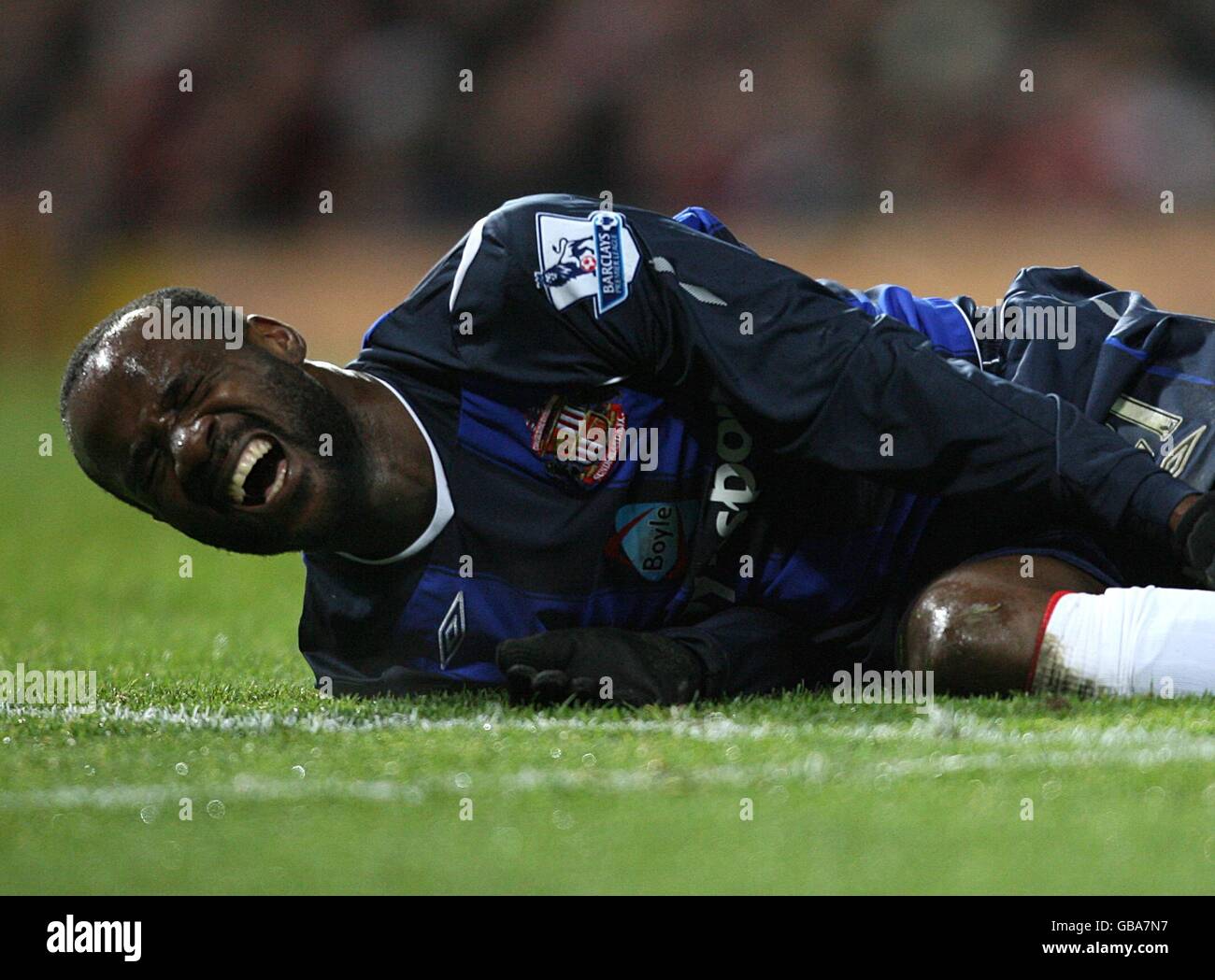 Sunderlands pascal chimbonda writhes in pain on the pitch hi-res stock ...