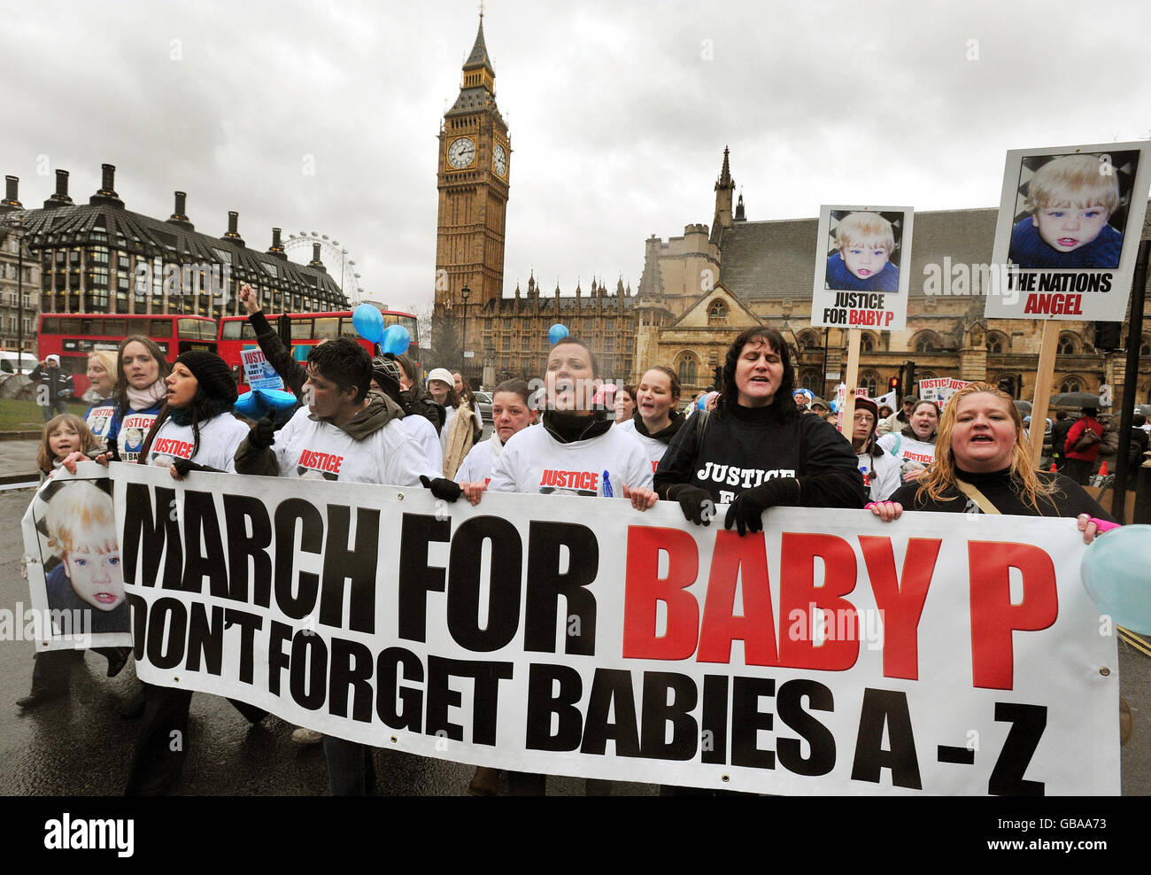 A large group of campaigners, some with their children, march around ...