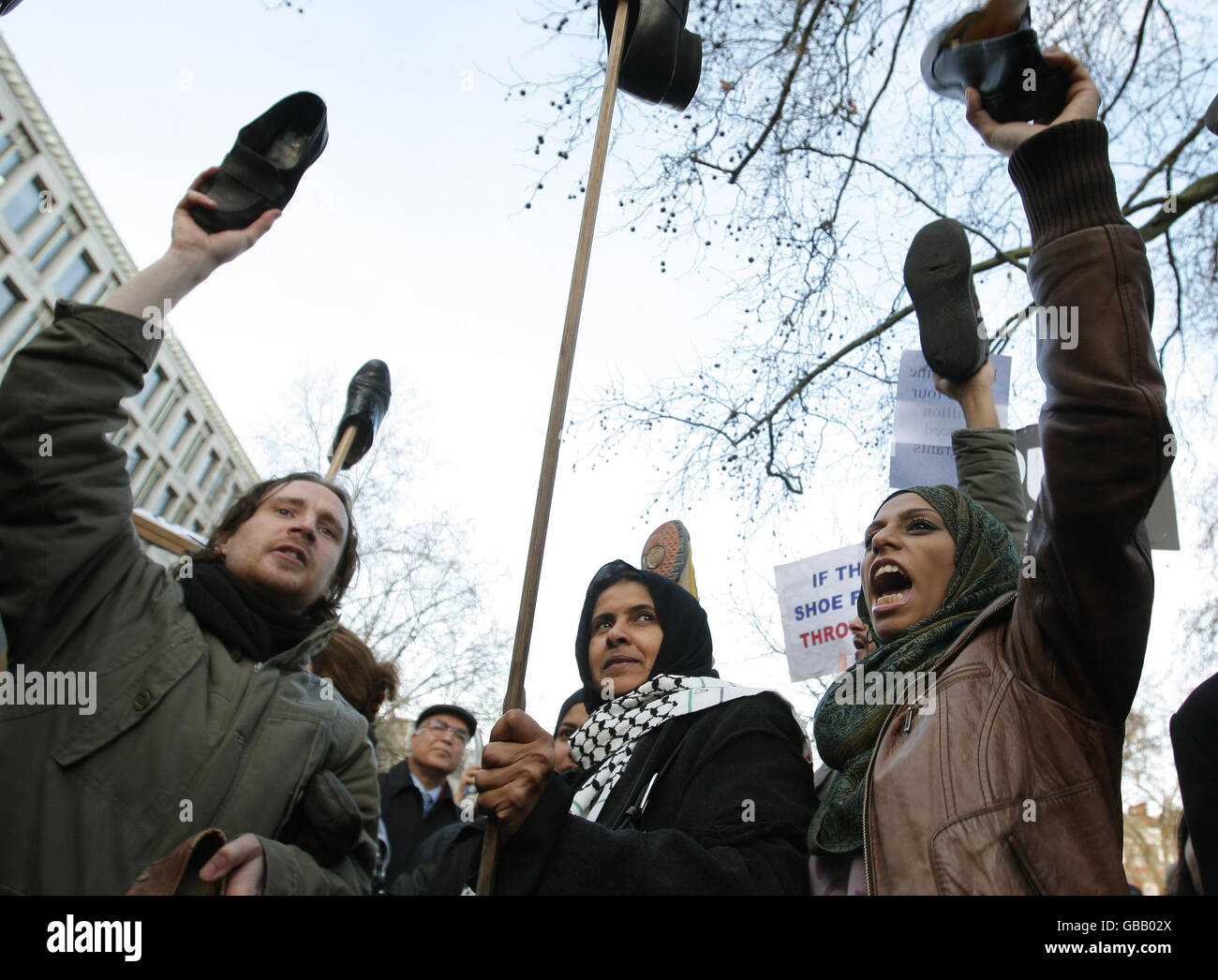 Protestors wave shoes in the air outside the American Embassy at ...