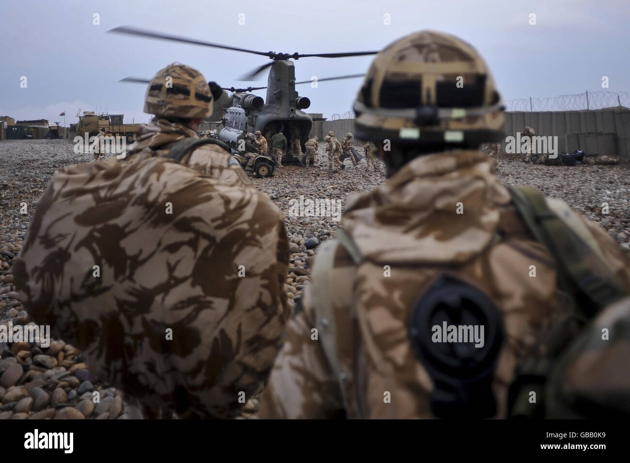 Soldiers prepare to board a Chinook helicopter at a Forward Operating ...