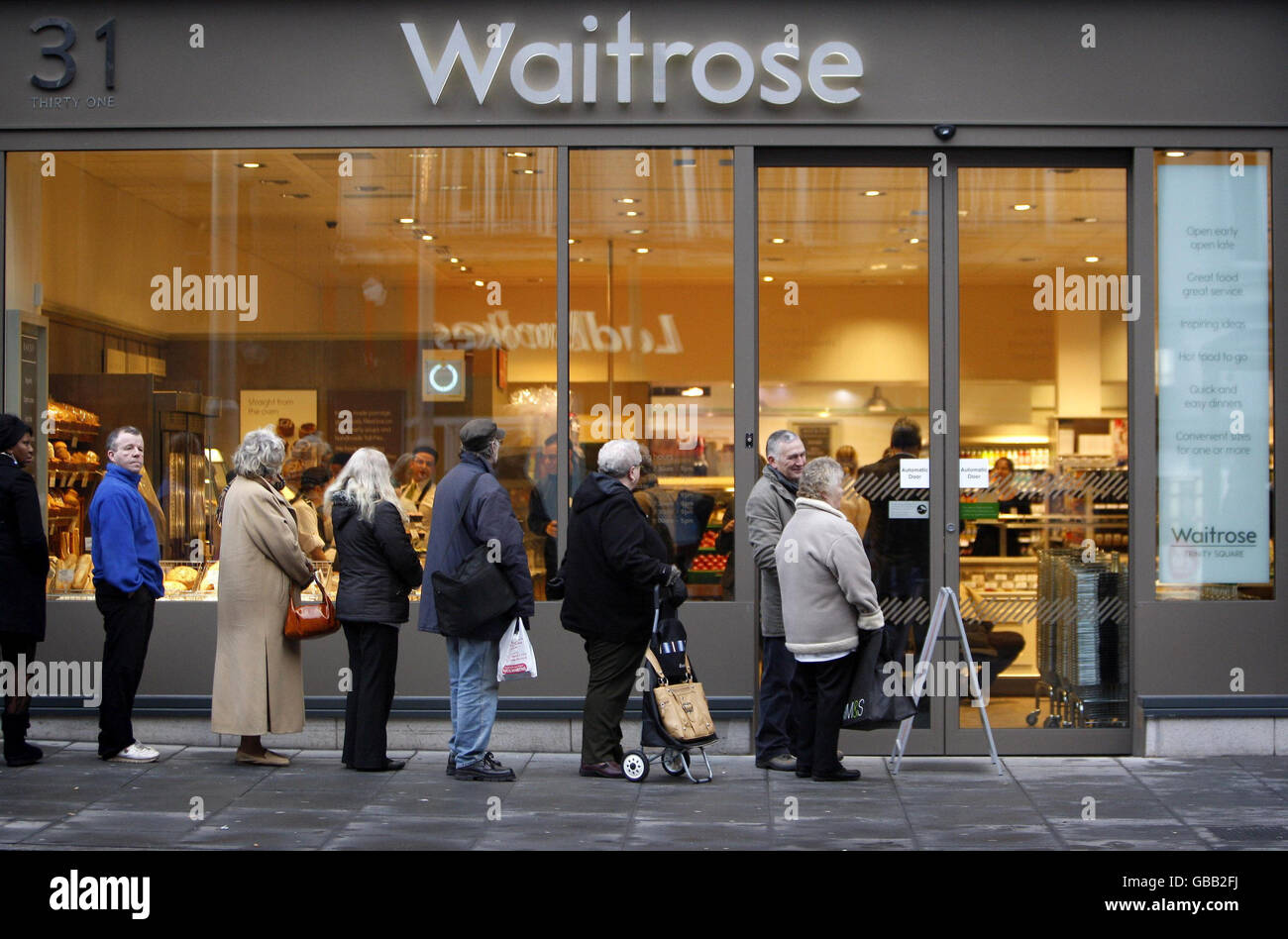 Customers queue outside the first Waitrose convenience store, which ...