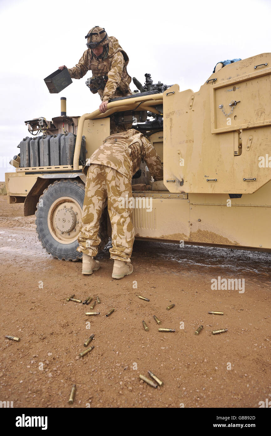 Soldiers clear up fired brass after test fireing a .50 cal machine gun ...