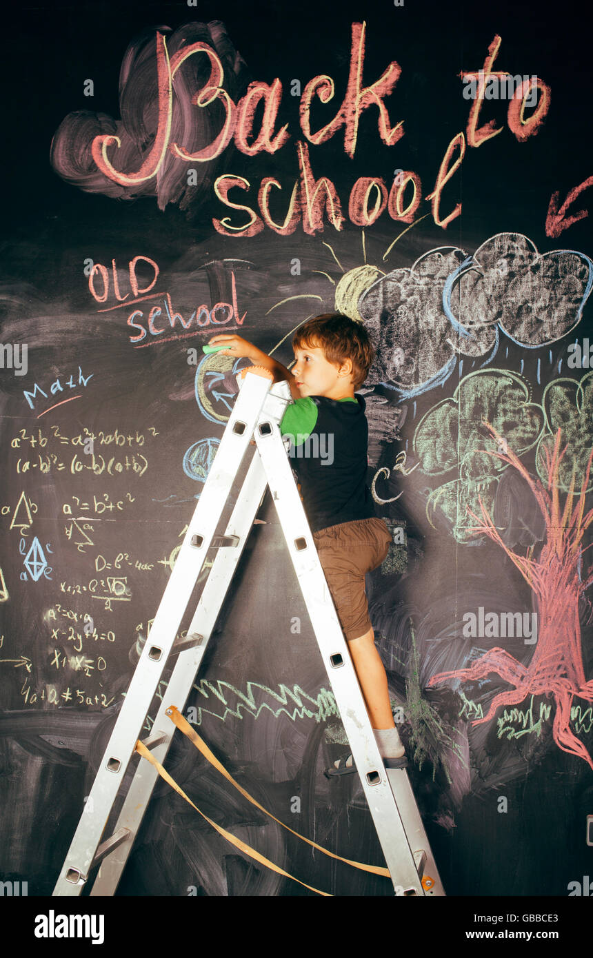 little cute real boy at blackboard in classroom, back to school close ...