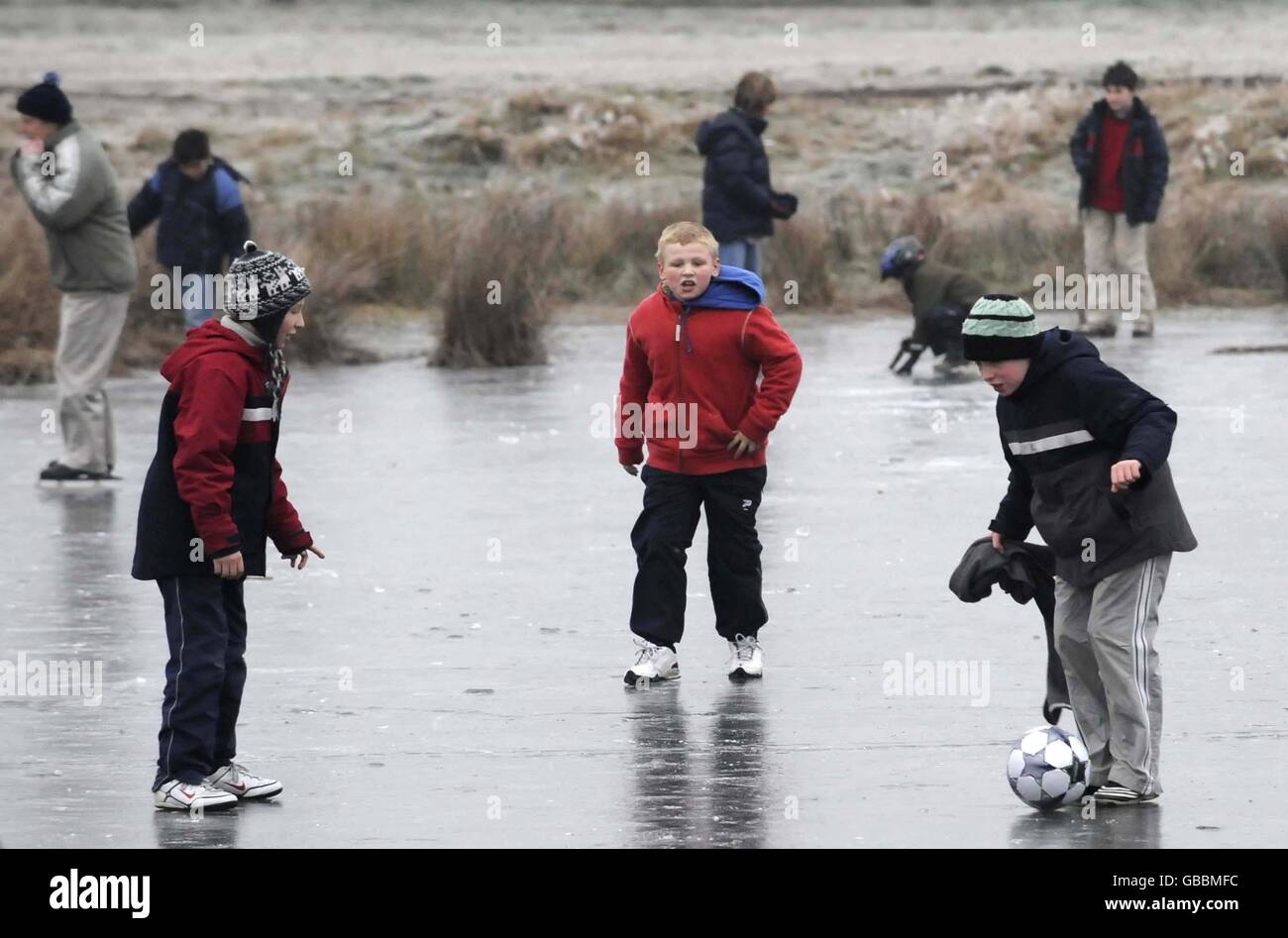 Boys play football on a frozen pond at Wimbledon Common as the cold ...
