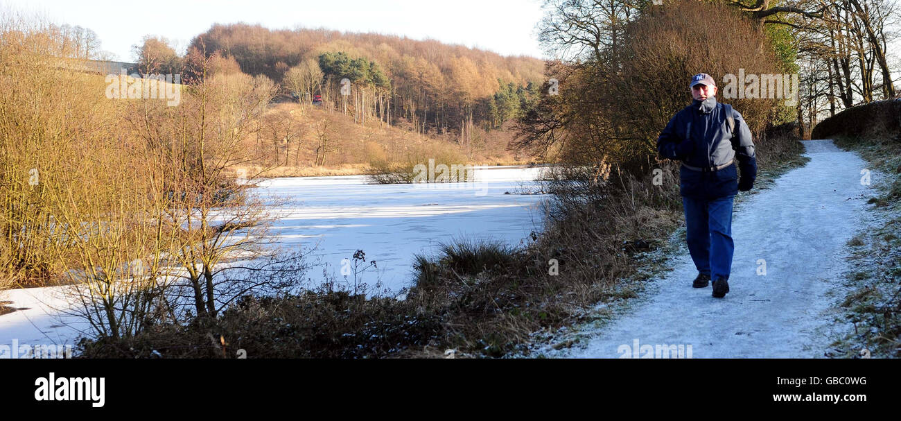 A man walks near the partially frozen Fewston Reservoir, near Harrogate ...