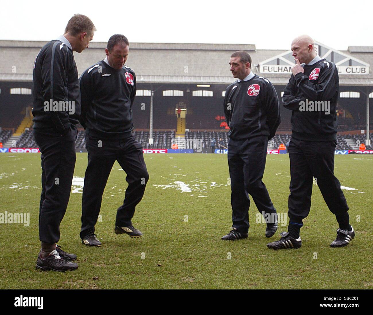 Match officials inspect the state of the pitch before match referee Rob ...