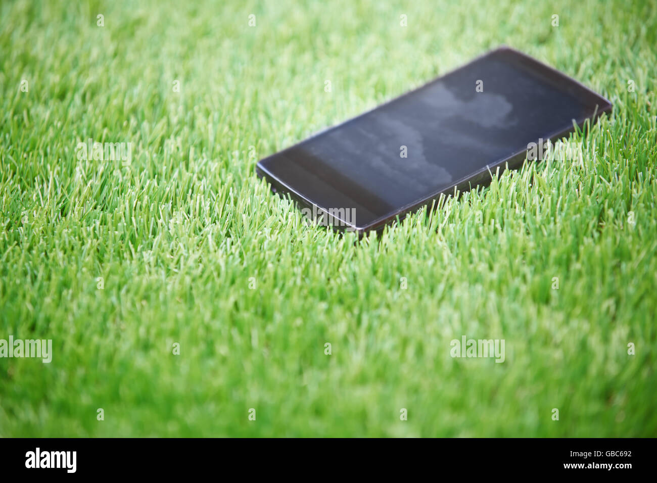 Smartphone lost in the grass. Horizontal photo Stock Photo - Alamy
