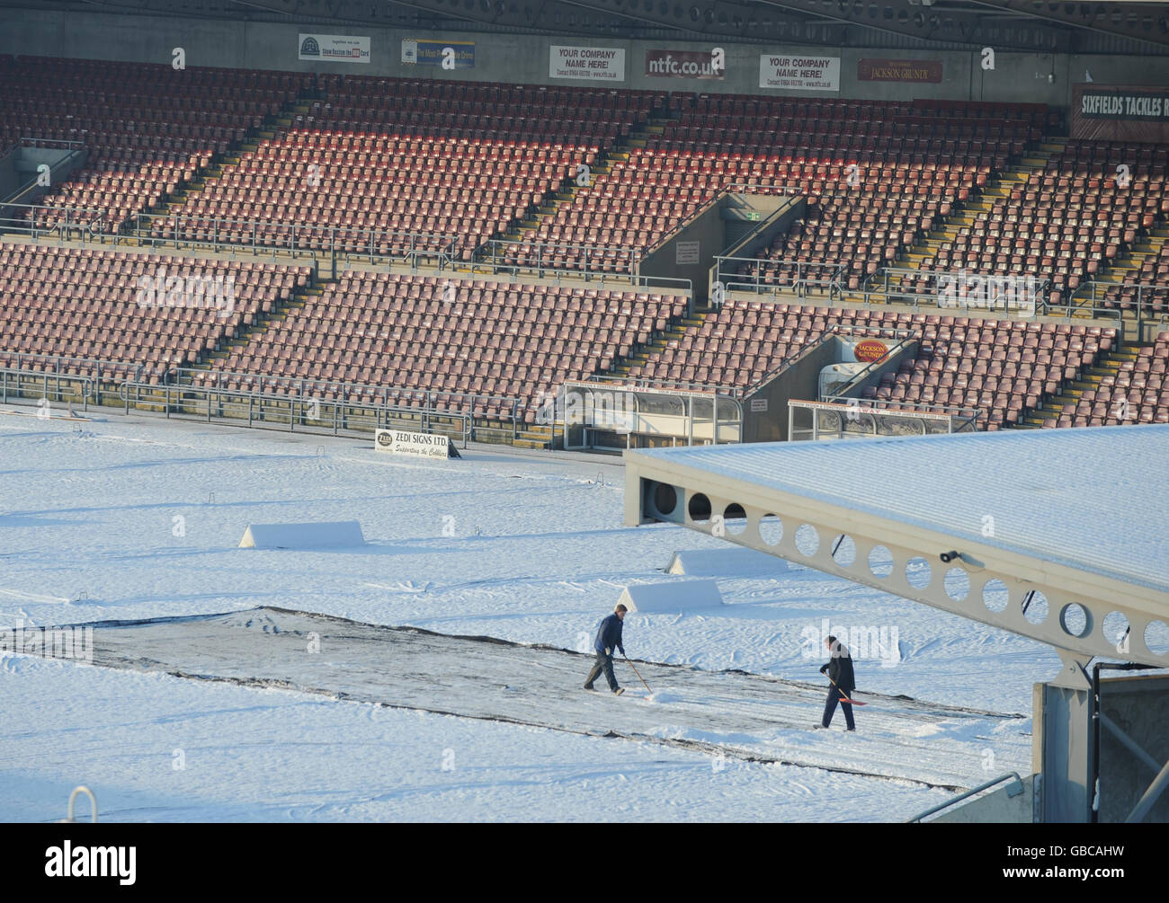 Groundstaff clear snow off the pitch at Northampton Town's Sixfields ...