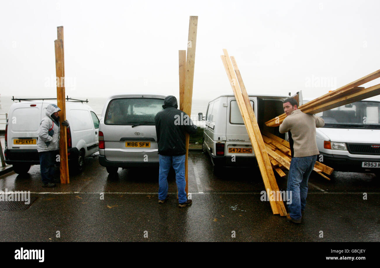 People load vans with timber from the beach in Ramsgate, Kent, washed ...