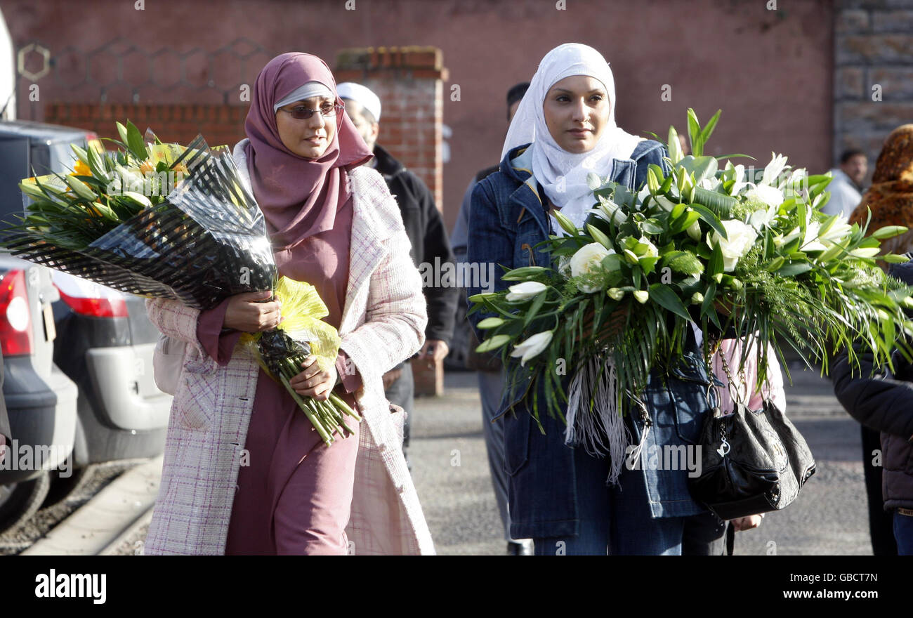 Mourners bring flowers to the funeral of the first Muslim member of the ...