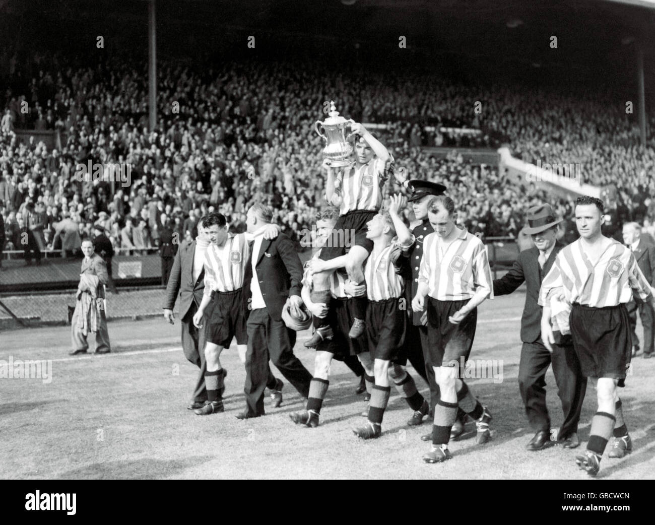 Sunderland captain Raich Carter displays the FA Cup as he is chaired ...