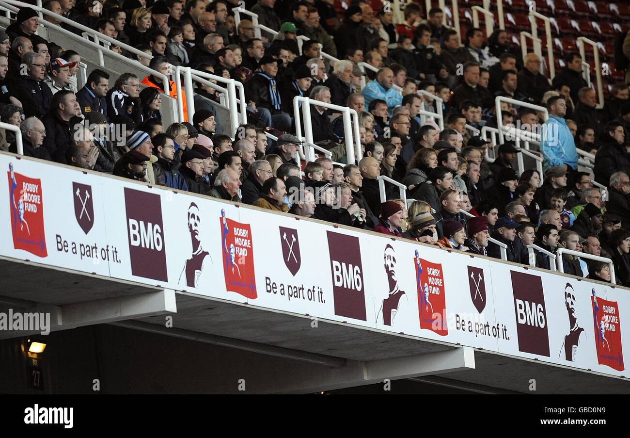 A advertisment promotes the Bobby Moore Fund, as fans watch the match ...