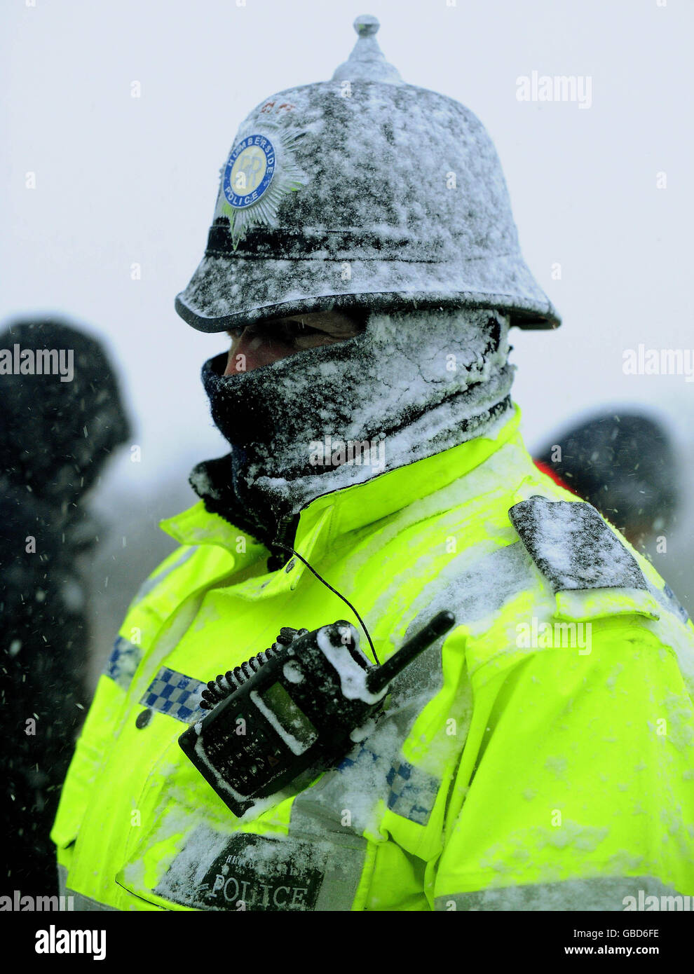 A police officer watches over the demonstration by workers outside the ...